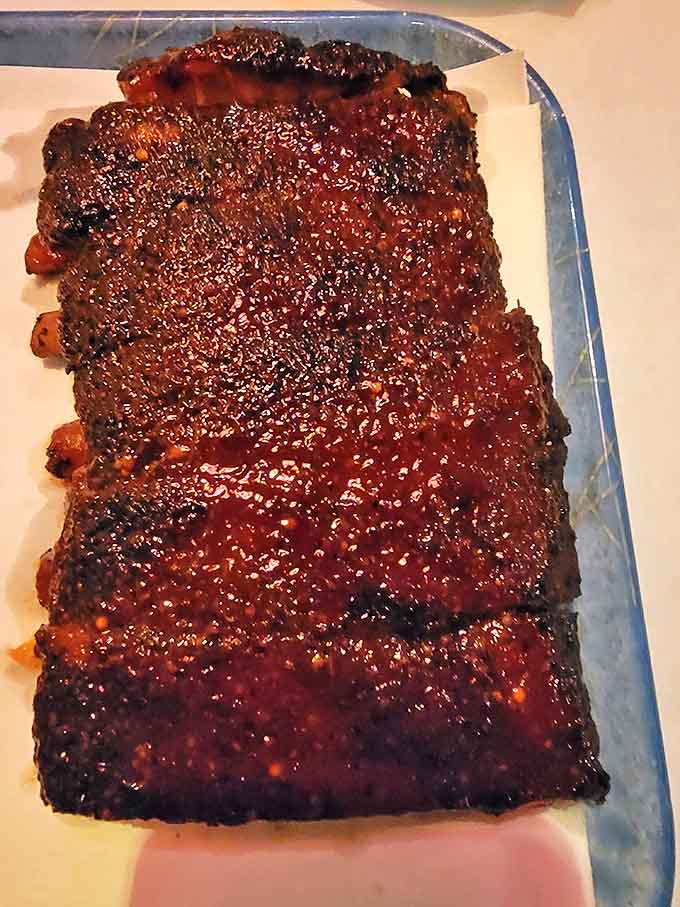 These ribs aren't just glazed—they're lacquered with barbecue perfection. The bark has that mahogany shine that says "I'm worth the mess."