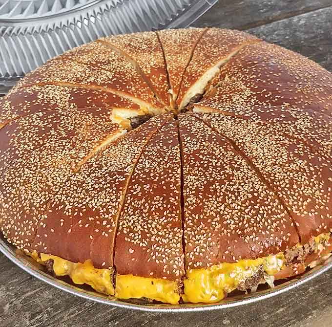 The sesame-studded bun wears its cheese like a molten crown. This isn't just a burger&mdash;it's architecture, engineering, and art all in one edible package.