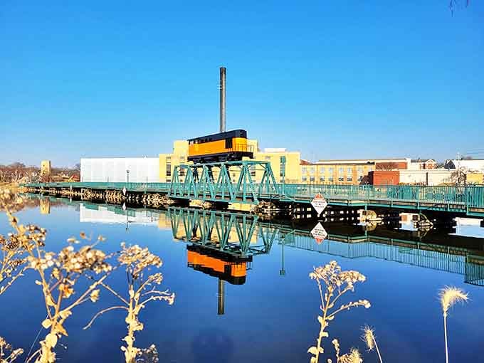 Beloit's industrial heritage shines along the Rock River, where the turquoise bridge perfectly mirrors in the calm waters.