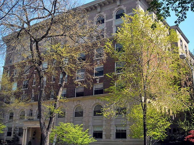Historic brick building in Northumberland surrounded by spring foliage, offering affordable senior housing options.