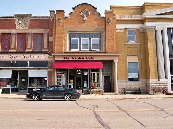The Garden Gate's cheerful red awning signals a shop where browsing comes with conversation and maybe a bit of friendly advice.
