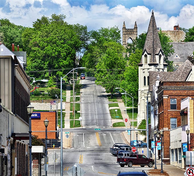 Rolling hills create a dramatic backdrop where church spires reach skyward like prayers for prosperity.