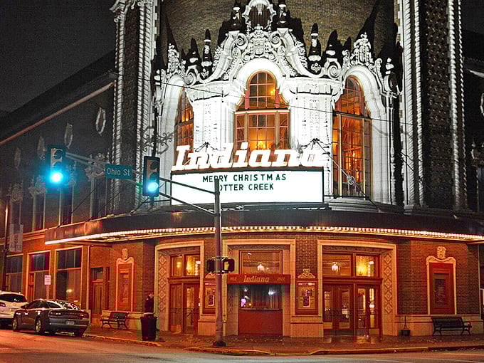 The Indiana Theatre's marquee glows like a beacon in Terre Haute's night, offering entertainment that won't dim your retirement savings.