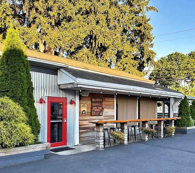 Red door, wooden panels, and a row of evergreens—the perfect camouflage for a BBQ joint that's serious about flavor.