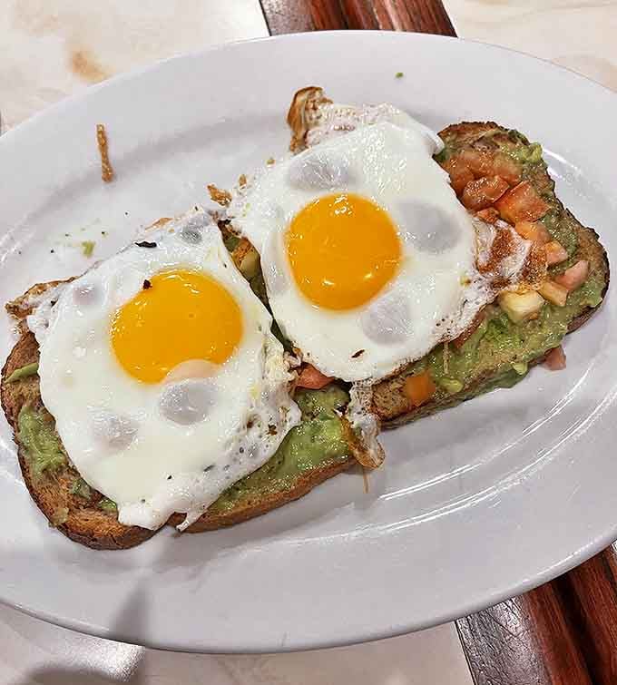 Avocado toast that would make millennials weep with joy, topped with sunny-side eggs that practically high-five your taste buds.