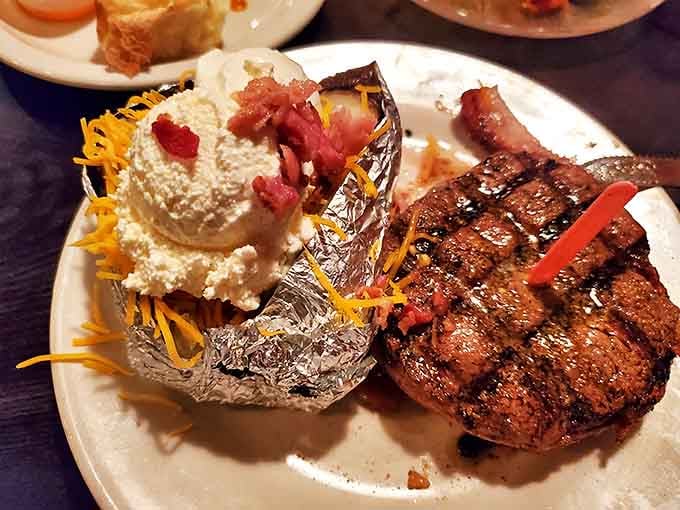 A loaded baked potato that doesn't just accompany the steak&mdash;it competes for the spotlight. That bacon and cheese topping isn't just garnish, it's a declaration of delicious intent.