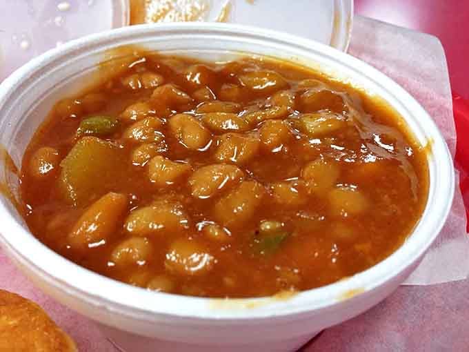 These baked beans have clearly been simmering since dawn, absorbing smoky wisdom and developing the kind of depth you can't rush.