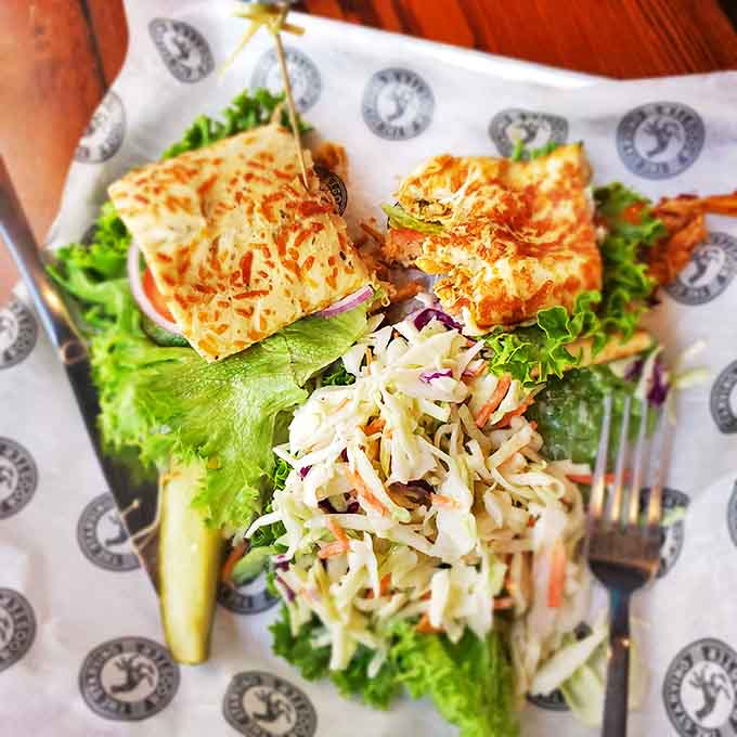 A sandwich that demands to be photographed before eaten, nestled beside a mountain of house-made chips that crackle with each bite.