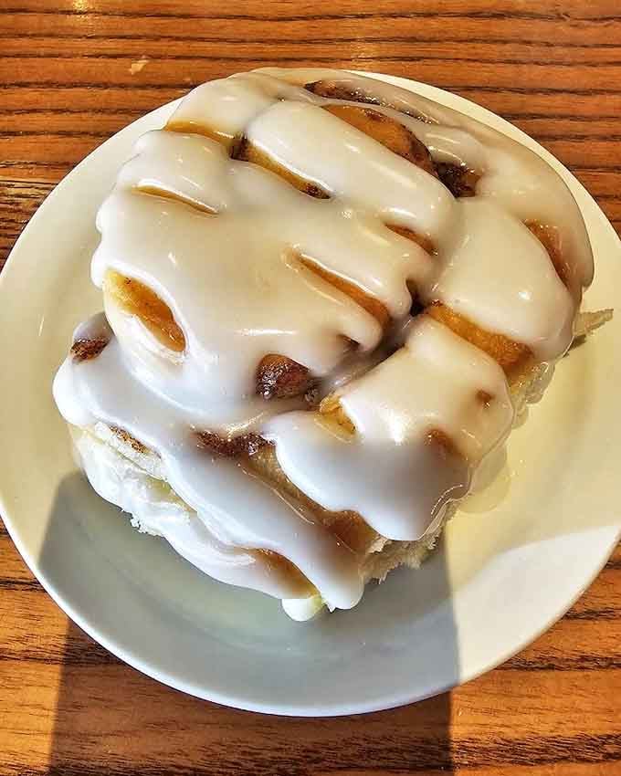 This cinnamon roll isn't just breakfast&mdash;it's an event. Pillowy dough spirals beneath a waterfall of icing that knows no restraint.