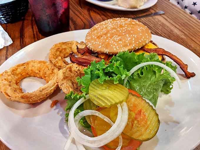 A burger that requires a game plan before the first bite &ndash; notice how the pickles and onions peek out like they're saying "just try to eat this neatly."