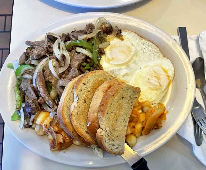 A hearty breakfast platter that says "I've got you covered" with eggs, steak, and toast—the holy trinity of diner perfection.