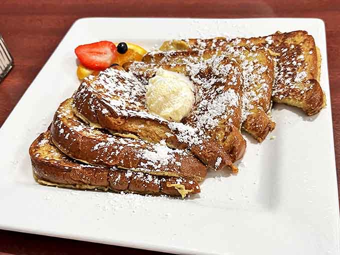 French toast that's achieved that magical balance: crispy edges, custardy center, and enough powdered sugar to make your dentist wince approvingly.