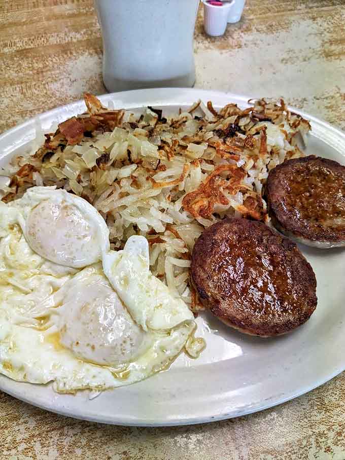 Hash browns crisped to golden perfection, eggs with yolks ready to create their own sauce, and sausage patties that mean business.
