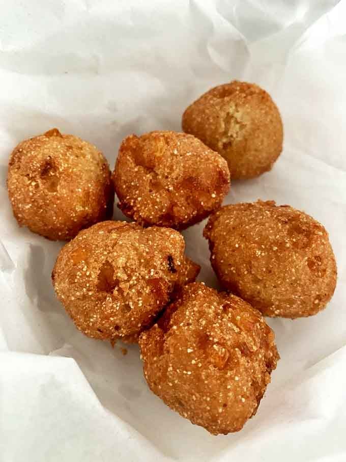 These hush puppies aren't telling tales, but they're speaking volumes about perfect frying technique and seasoned cornmeal magic.