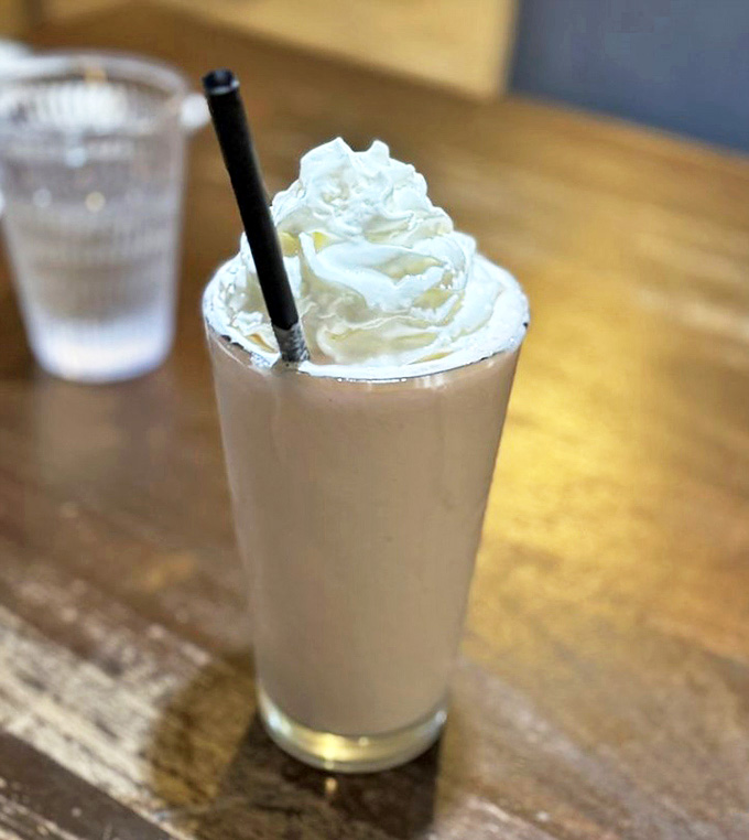 A milkshake crowned with a cloud of whipped cream stands ready to transform your day from ordinary to extraordinary. Straws were invented for moments like this.