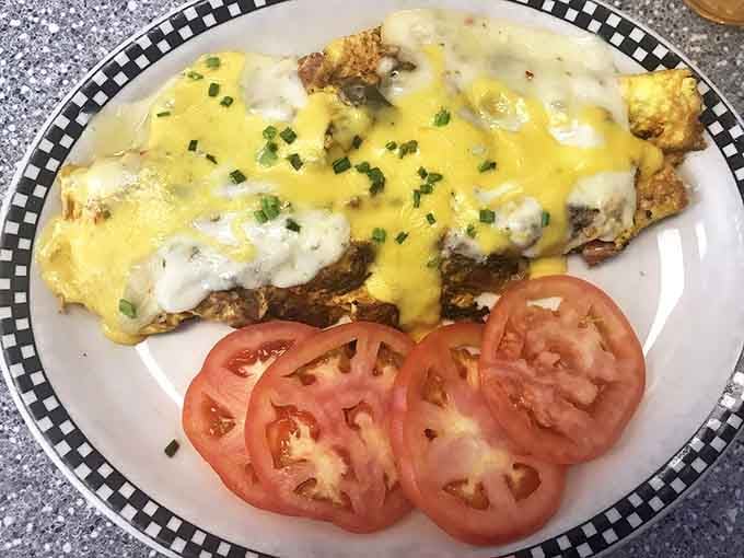 An omelet that's seen more cheese than a Wisconsin dairy farm, topped with a sunshine-yellow sauce that screams "good morning!"
