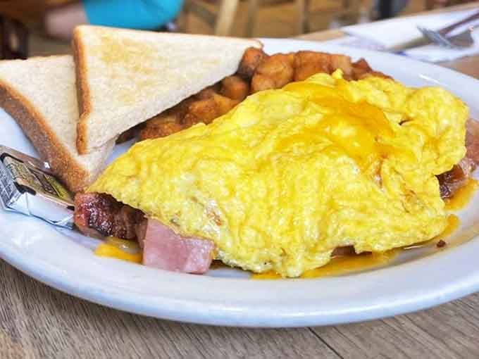 This isn't just an omelette; it's a golden sunrise of eggs embracing ham and cheese with the enthusiasm of a reunion.
