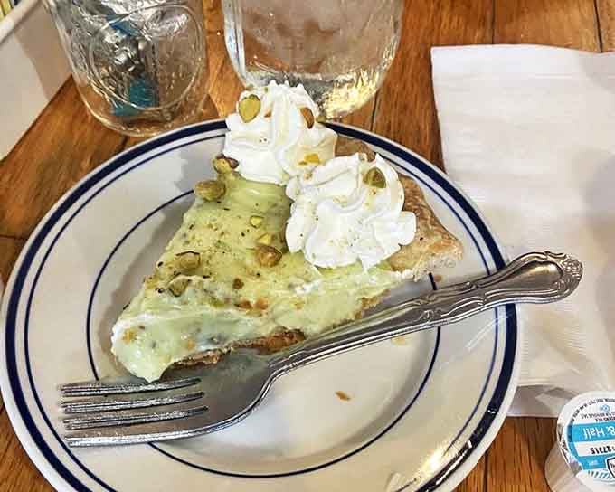 Pistachio pie topped with whipped cream&mdash;the kind of dessert that makes you consider ordering a second slice before finishing the first.