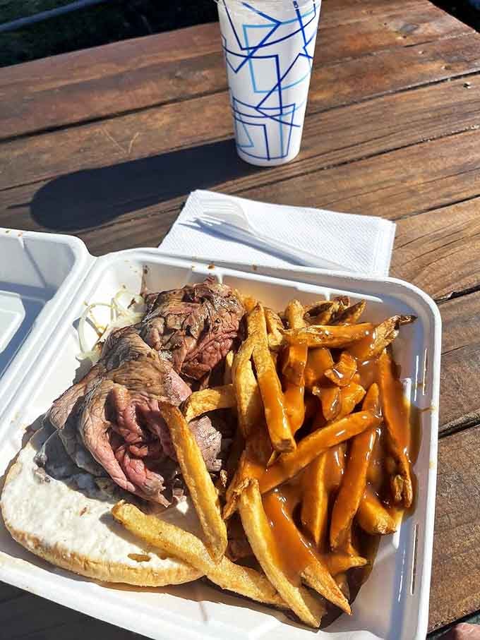 Al fresco dining at its most honest&mdash;a styrofoam container, golden fries with gravy, and beef that makes you forget you're eating at a picnic table.