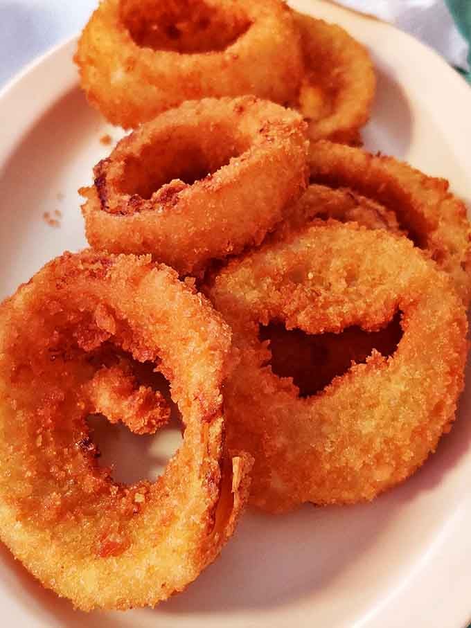 These golden onion rings aren't just a side dish&mdash;they're crispy halos of happiness that make you wonder why anyone would ever choose fries instead.