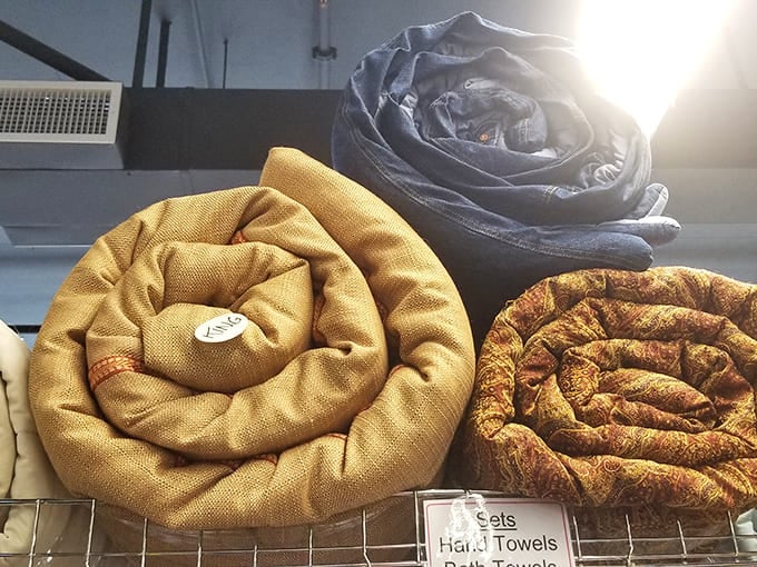 Textile art in circular form. These rolled blankets transform from practical warmth to sculptural beauty, proving thrift stores understand presentation matters too.