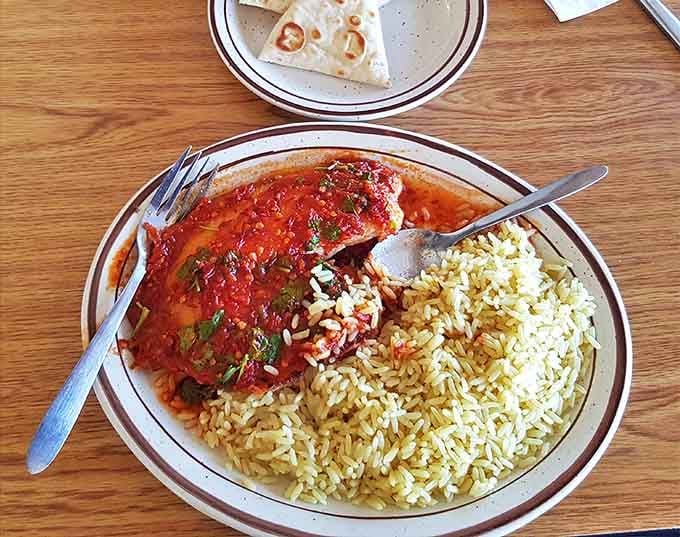 The vibrant tomato sauce blankets the fish like a warm Mediterranean sunset, while the saffron-kissed rice stands ready to soak up every drop.