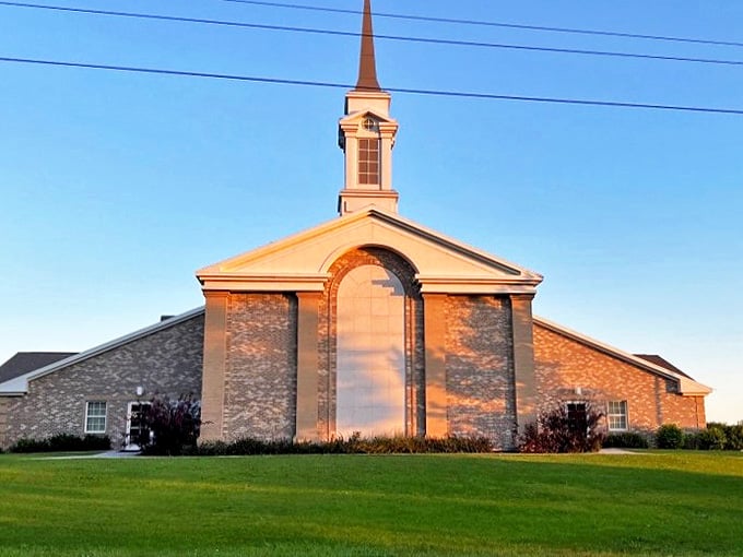 Bathed in golden hour light, this church stands as both architectural landmark and community cornerstone, its spire reaching skyward like the aspirations of its congregation.
