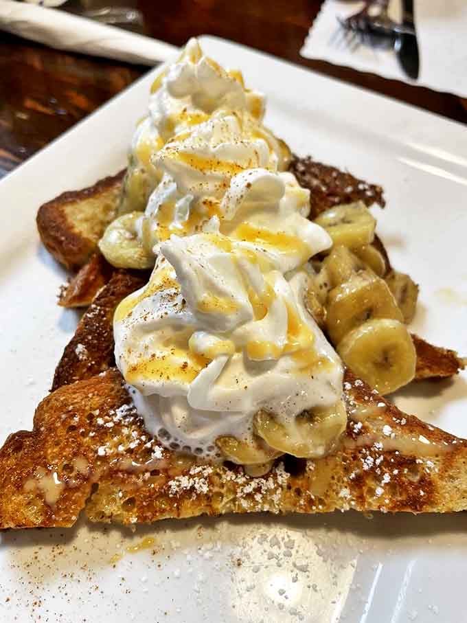 French toast that makes you question why anyone would eat anything else before noon—topped with a mountain of whipped cream and bananas.