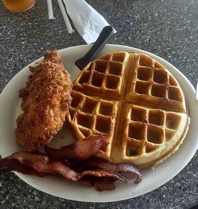 The holy trinity of breakfast indulgence: golden waffle, perfectly crisped chicken, and bacon that means business. Diet starts tomorrow.
