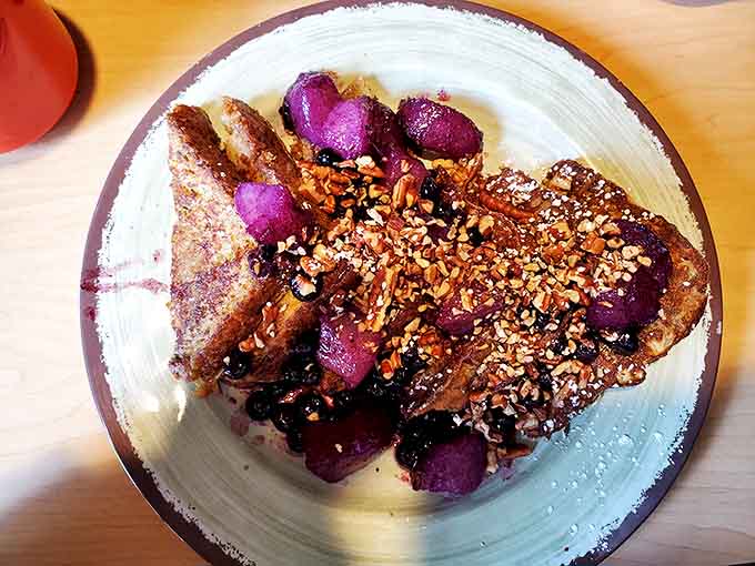 French toast that looks like it graduated from culinary school, adorned with fruit and nuts in a presentation that's almost too pretty to eat. Almost.