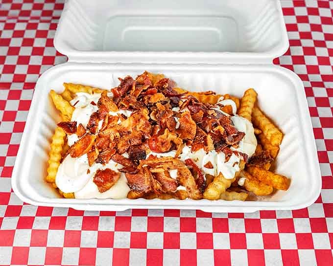 French fries achieve their higher purpose when topped with cheese sauce and bacon bits&mdash;a glorious caloric commitment worth every delicious consequence.