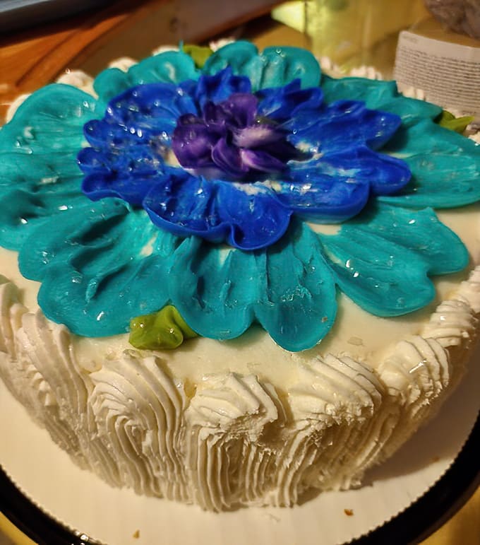 A flower blooms in frosting form. This cake isn't just dessert – it's a celebration centerpiece that's almost too pretty to eat. Almost.
