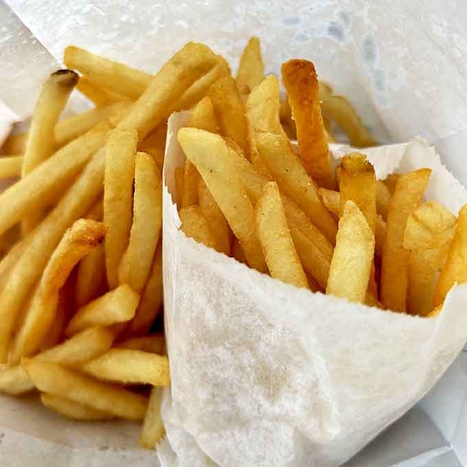 French fries so golden and crisp they deserve their own Instagram account. Wrapped in paper because some treasures don't need fancy packaging.