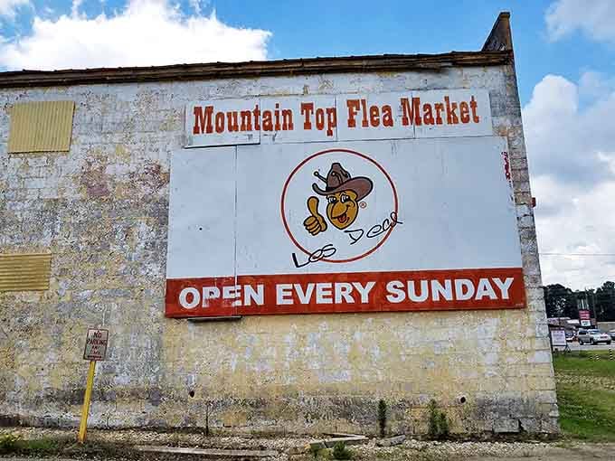 The weathered market sign featuring a thumbs-up mascot promises weekly treasure hunting opportunities every Sunday without fail.