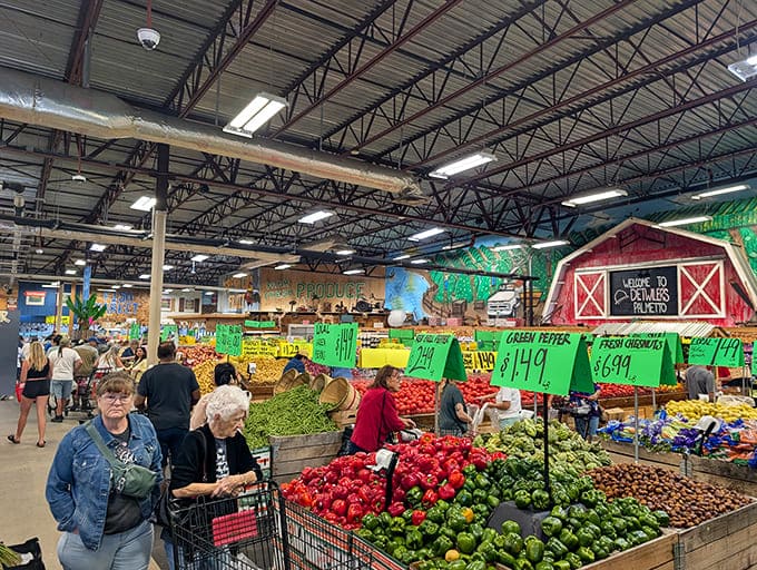 Shoppers navigating a sea of vibrant produce. The red peppers are so bright they could direct airport traffic.