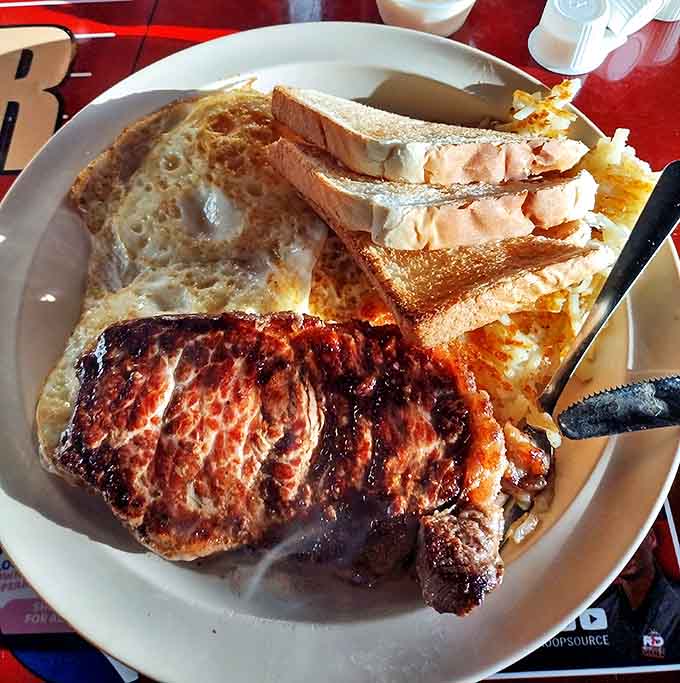 The holy trinity of breakfast: perfectly grilled steak, sunny-side-up eggs, and hash browns that have achieved that mythical crispy-yet-tender balance.