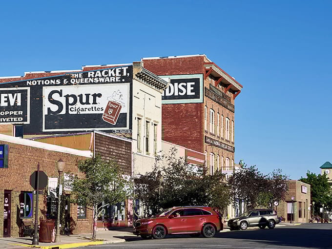Historic brick buildings in downtown Evanston showcase vintage painted advertisements against Wyoming's brilliant blue sky.