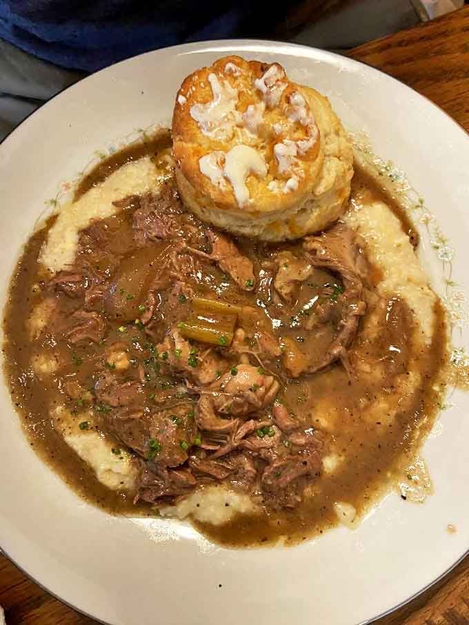 Slow-braised beef that's had a proper Southern upbringing &ndash; tender, rich, and resting on a cloud of creamy grits with a biscuit hat.