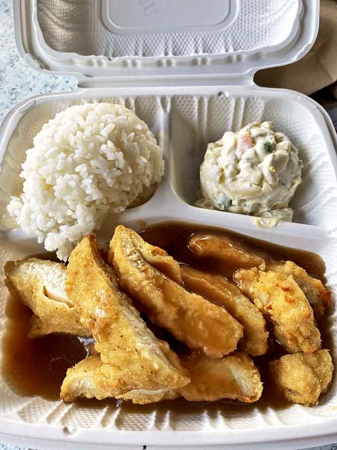 The holy trinity of Hawaiian plate lunches: perfectly sticky rice, creamy mac salad, and golden chicken swimming in gravy that should be bottled and sold.