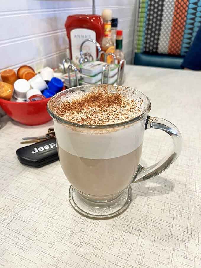 Their house chai doesn't just warm your hands—it hugs your soul, dusted with cinnamon that reminds you some mornings deserve more than plain coffee.