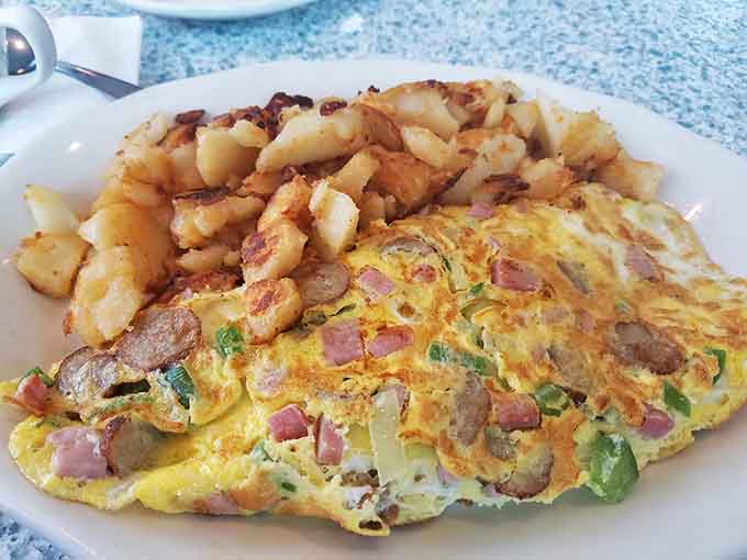 This isn't just any omelet—it's a masterclass in egg architecture, stuffed with ham and veggies that peek out with each perfect bite.