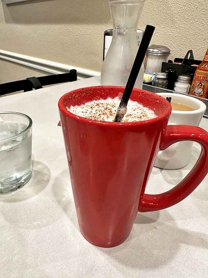 That red mug isn't just holding coffee &ndash; it's cradling liquid motivation with a dusting of cinnamon, ready to jumpstart your day.