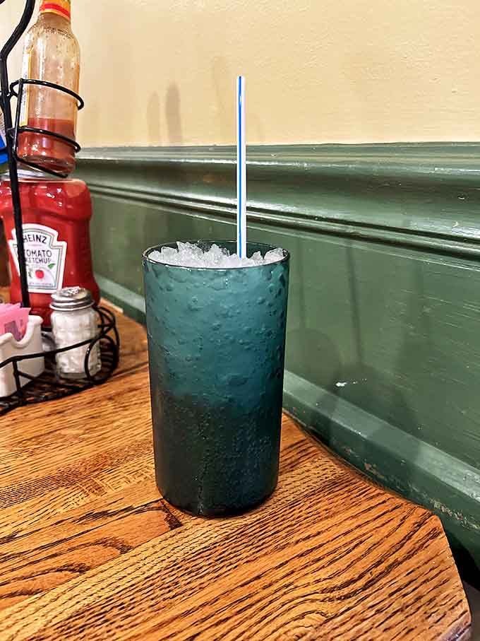 That blue drink isn't just refreshing &ndash; it's the unofficial mascot of Stoby's, standing tall and proud against the restaurant's signature green backdrop.