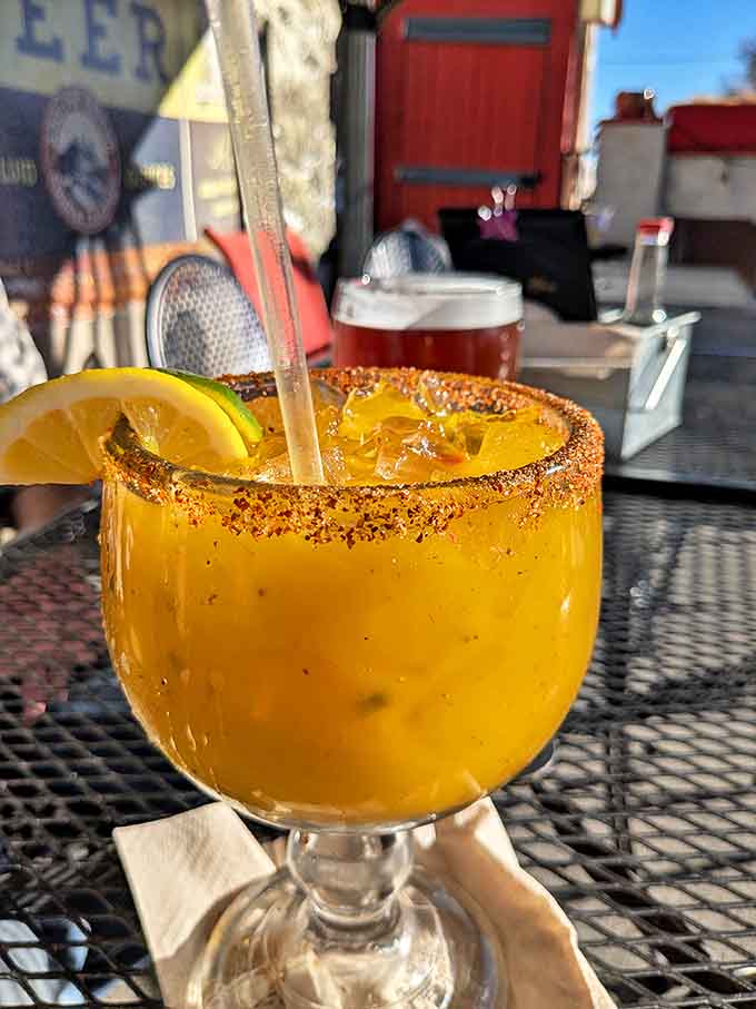 A margarita rimmed with chili powder catches the Colorado sun, promising refreshment with a spicy twist nearby.