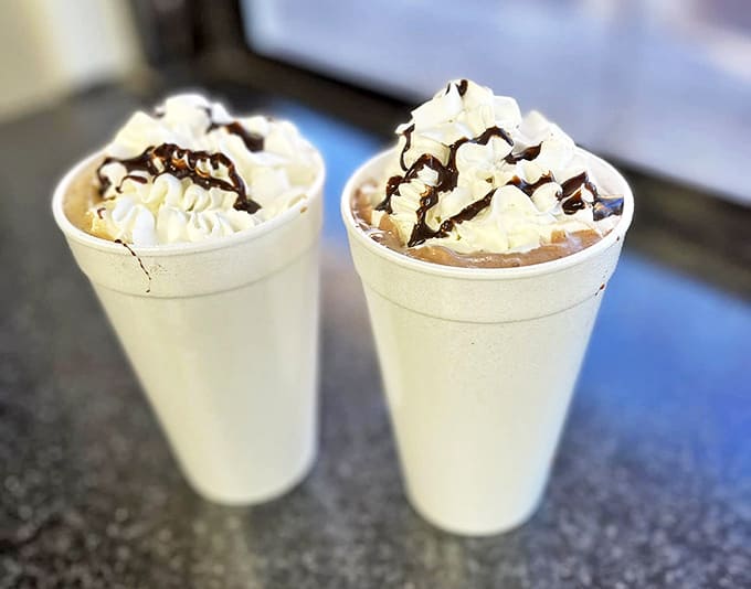 Milkshakes topped with whipped cream and chocolate drizzle—proof that sometimes the best things in life come in tall styrofoam cups.