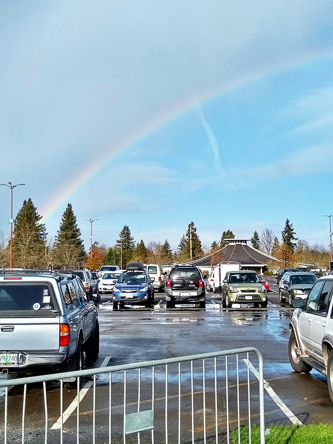 Even Oregon rain can't dampen treasure-hunting spirits. A rainbow appears as if to bless the parking lot filled with vehicles of determined bargain seekers.