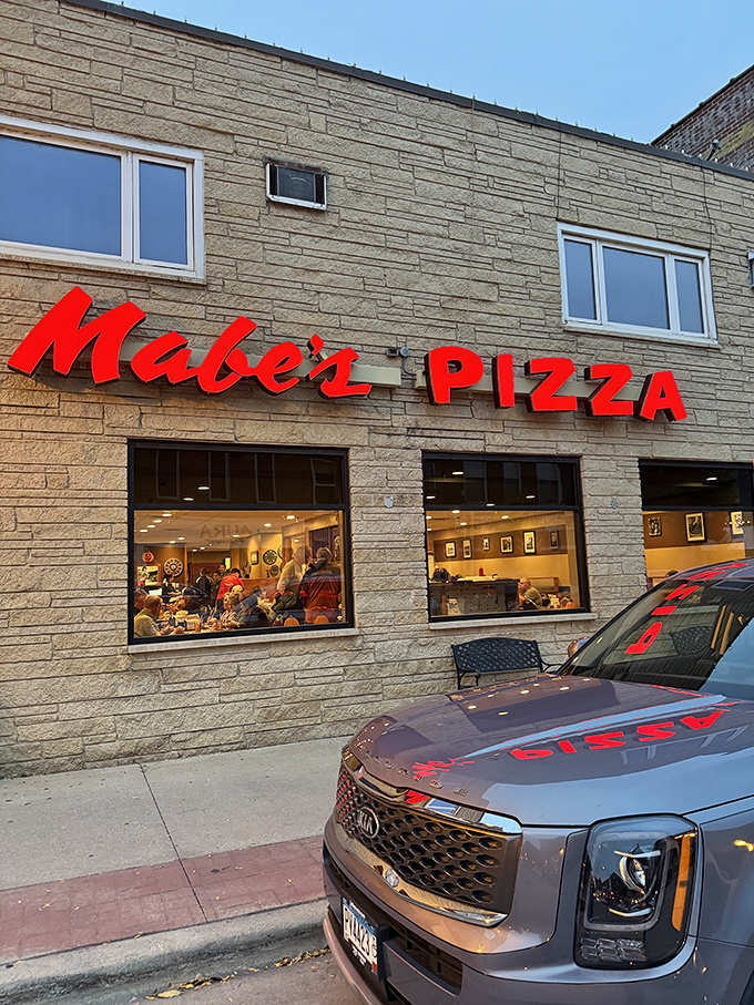 Mabe's glowing red sign against limestone is like a beacon calling hungry travelers home to pizza paradise in Decorah.