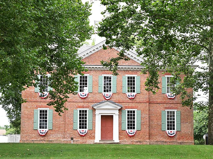 This stately brick courthouse in Edenton exudes colonial charm. Patriotic bunting adds a festive touch to its dignified facade.