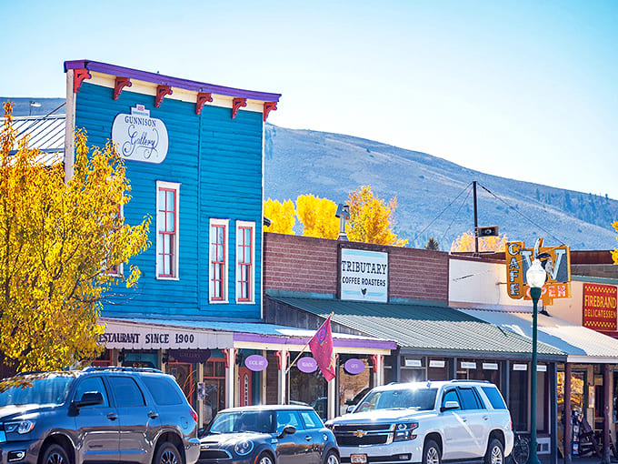Gunnison's vibrant blue buildings pop against the mountain backdrop like a painter's happy accident.