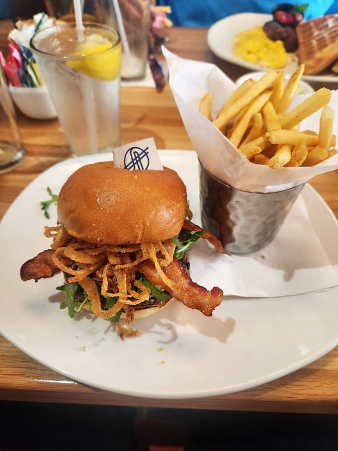 A burger that demands a two-handed commitment, topped with crispy onions that shatter like delicious glass with each magnificent bite.
